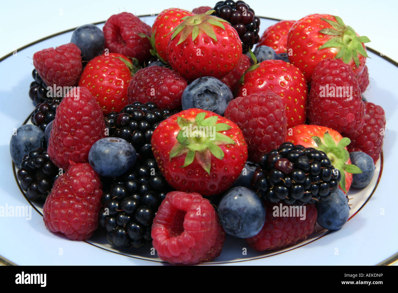 Mixed berries on a plate low level close up landscape view Stock Photo ...