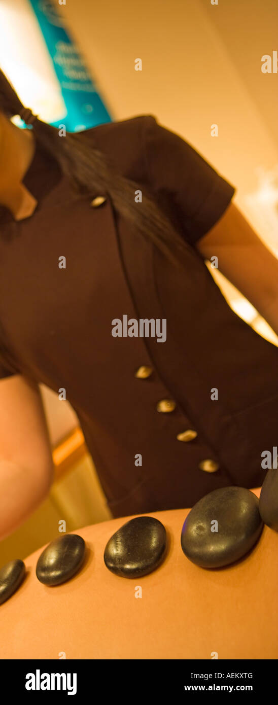 THERAPIST APPLYING HOT STONES Stock Photo - Alamy