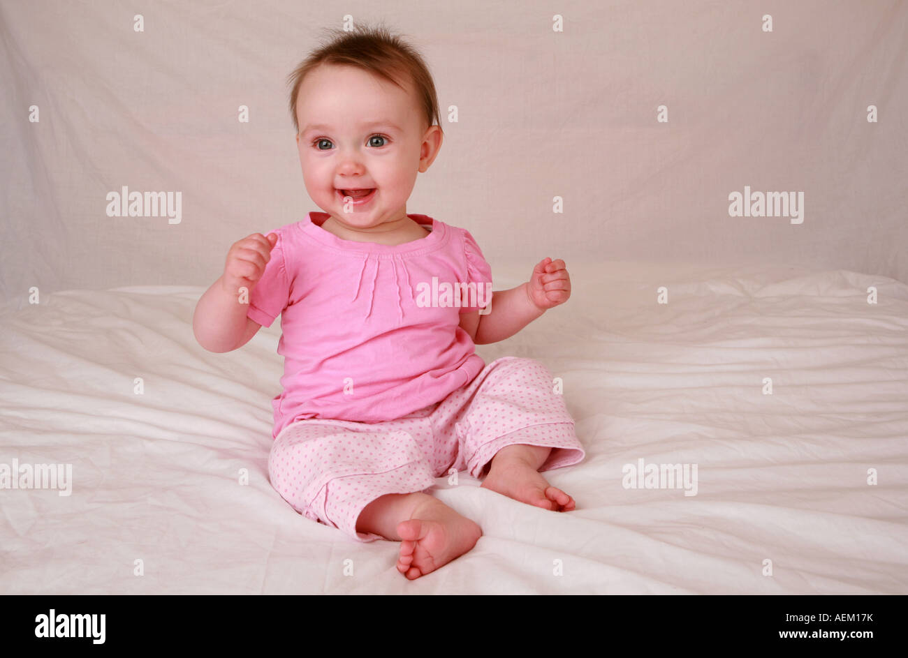 Cute adorable angelic newborn baby in first year sitting up and smiling ...