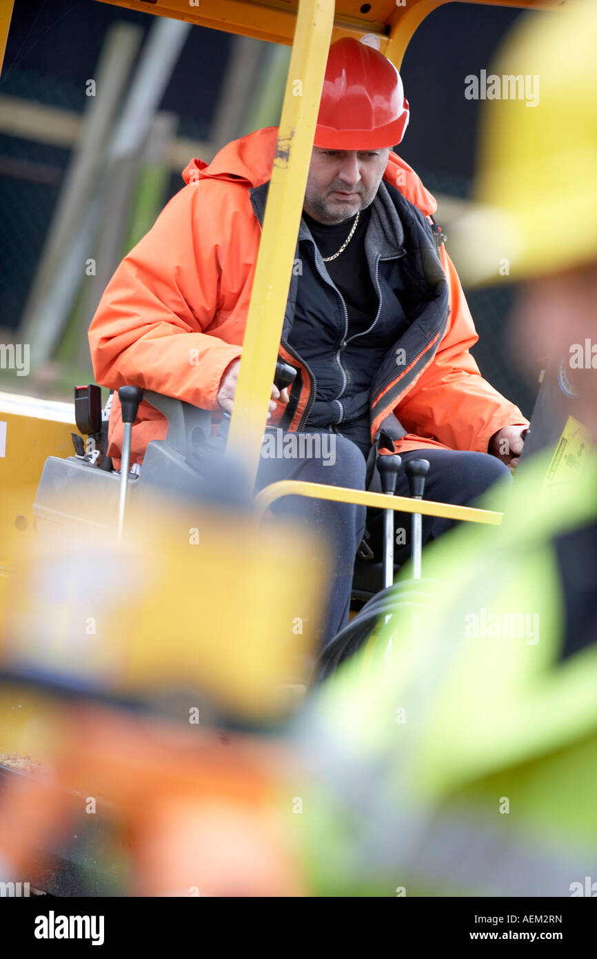 CONSTRUCTION SITE WORKERS WITH SITE LEVEL AND DIGGER DRIVER Stock Photo ...