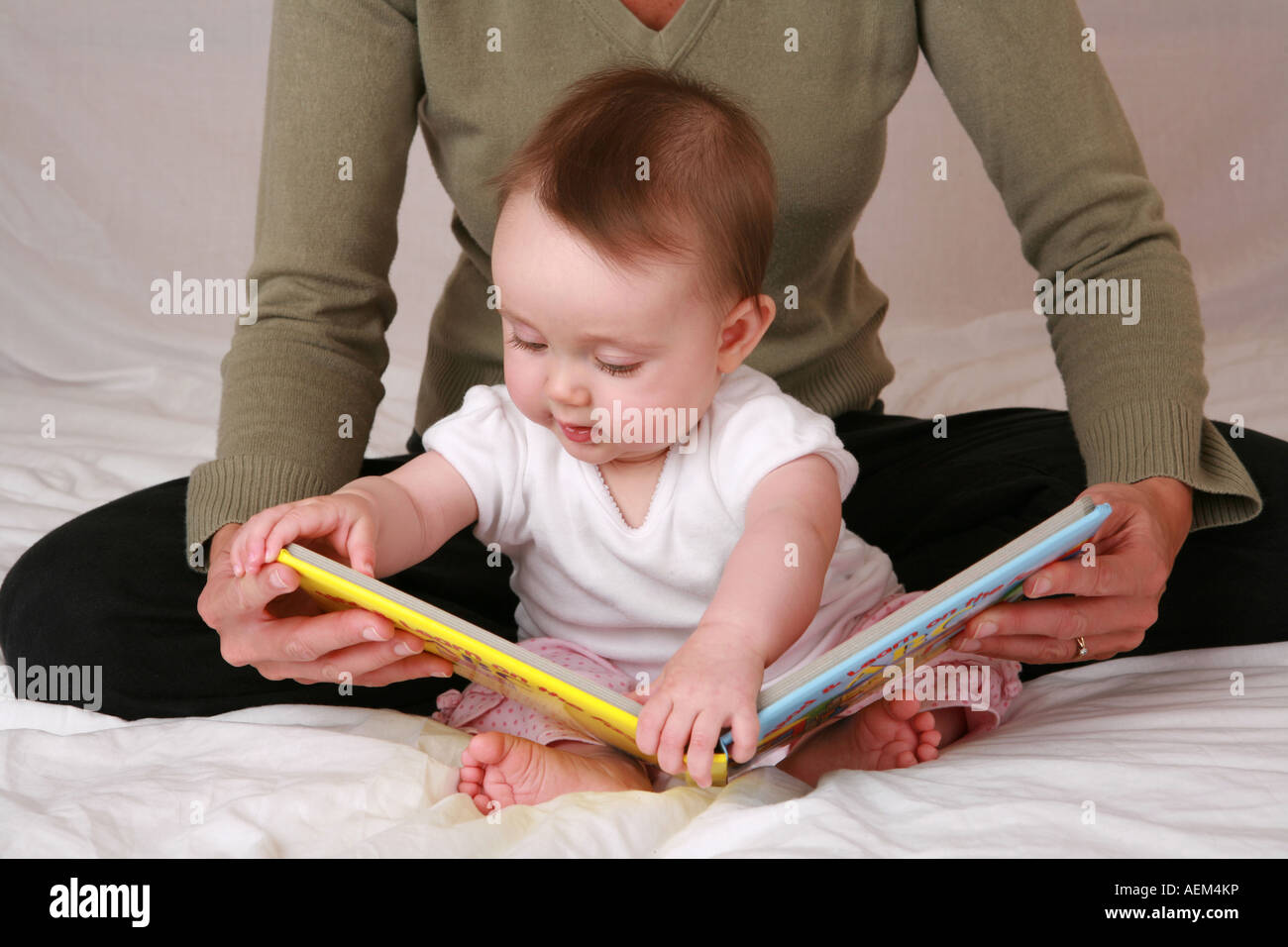Young newborn baby enjoying story time reading learning studying with ...