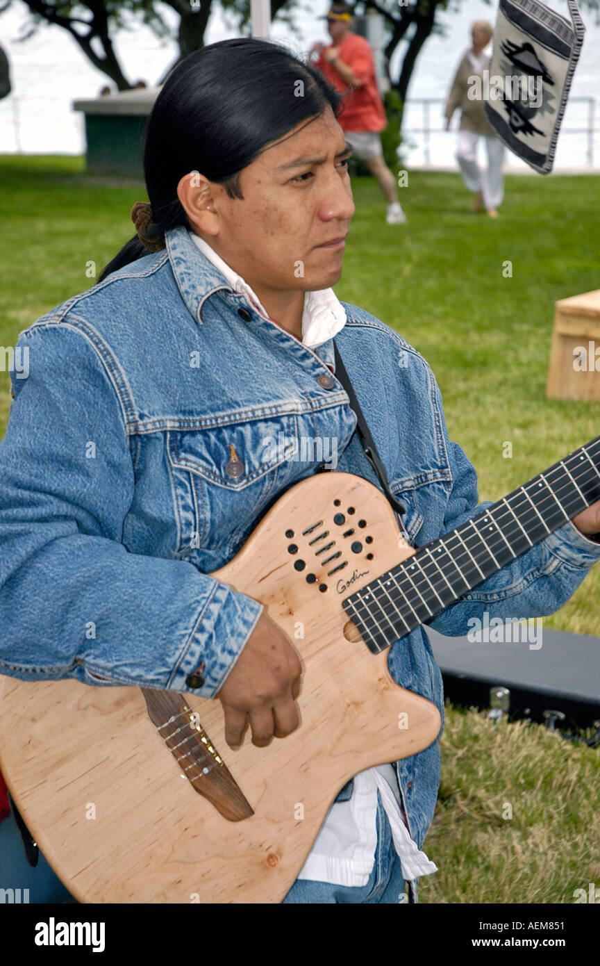 Peruvian Indian plays music on a guitar to sell personal CD s at a ...