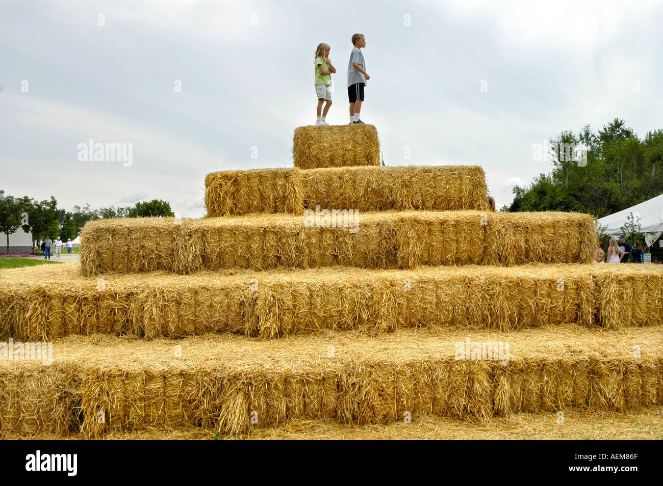 Kids climb to the top of a pyramid made from bails of hay Stock Photo ...