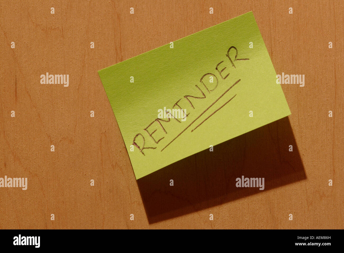 Reminder post it note stuck to wall Stock Photo - Alamy