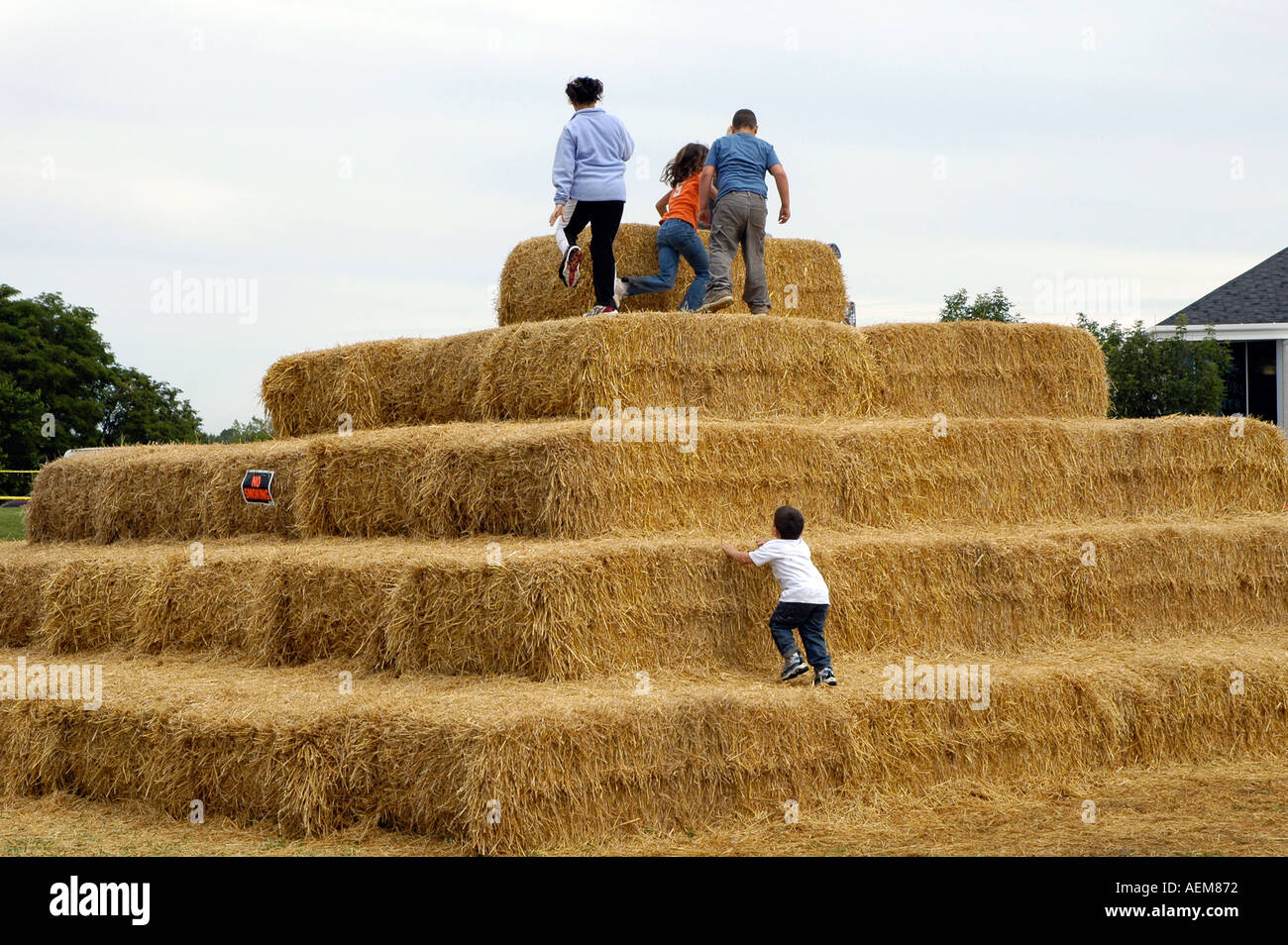 Kids climb to the top of a pyramid made from bails of hay Stock Photo ...
