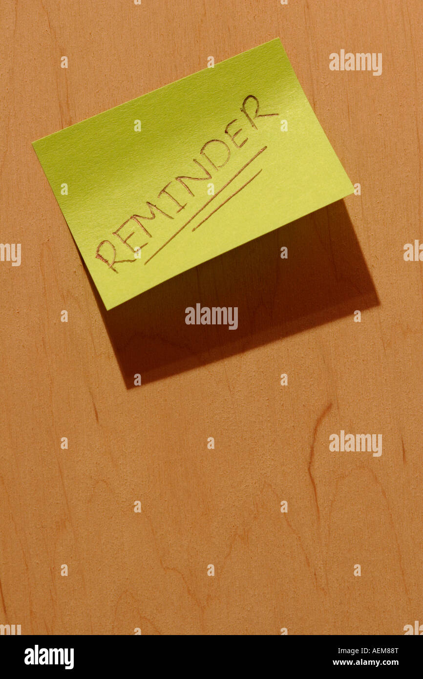 Reminder post it note stuck to wall Stock Photo - Alamy