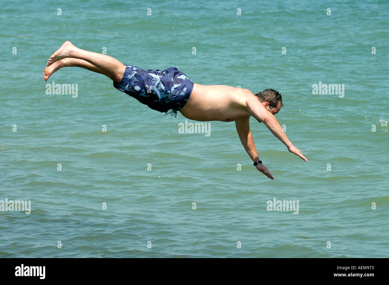 Adult male dives into water Stock Photo - Alamy
