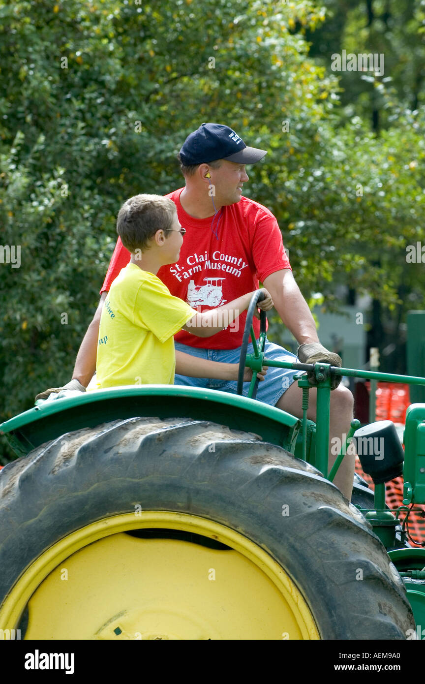 Father allows son to drive a farm tractor Stock Photo - Alamy