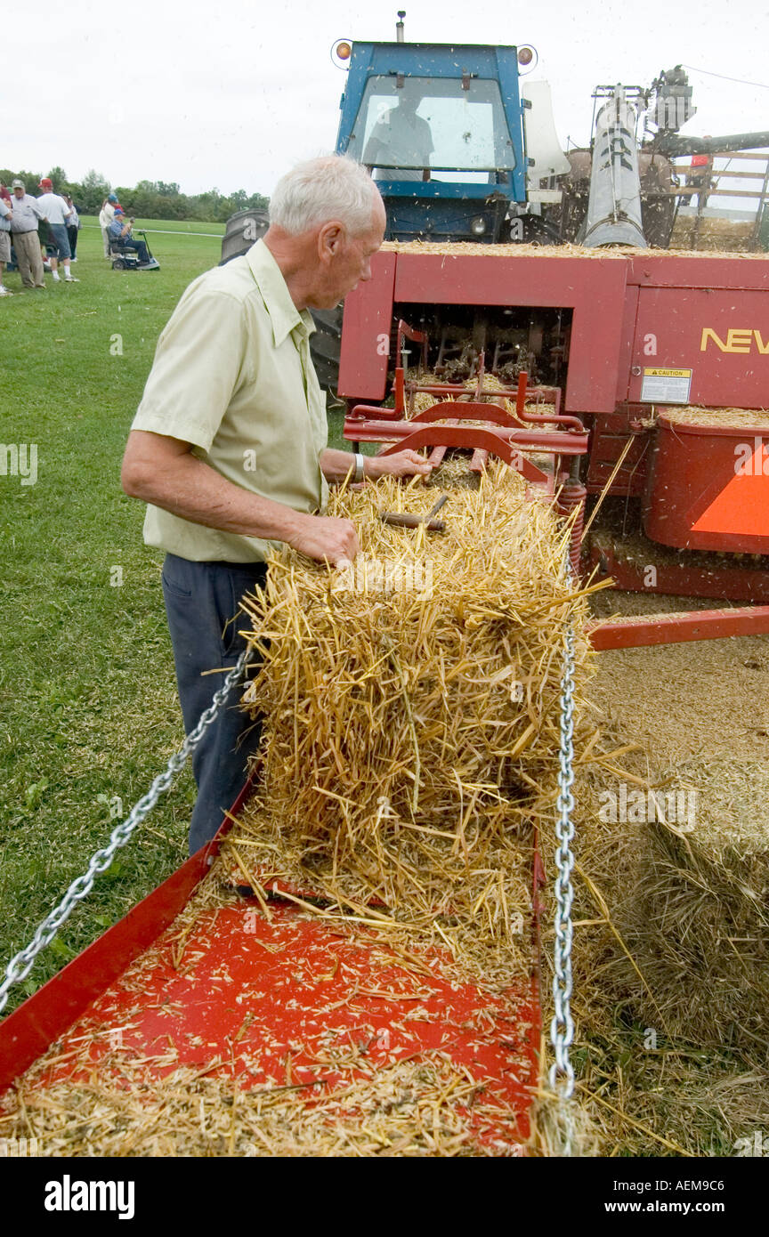 Local farmers demonstrate hay bailing techniques in a circa 1920 saw ...