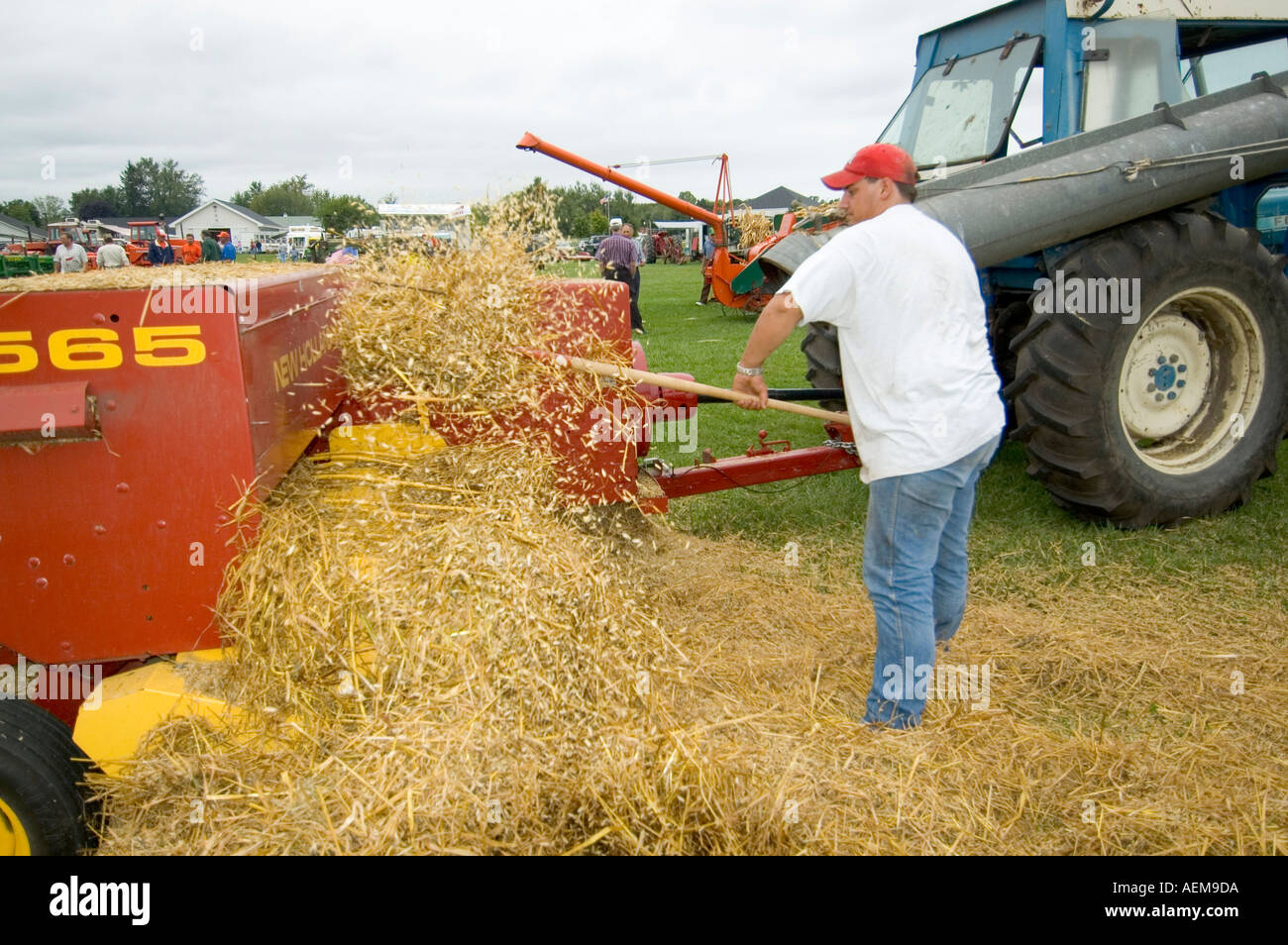 Local farmers demonstrate thrashing oats using techniques in a circa ...