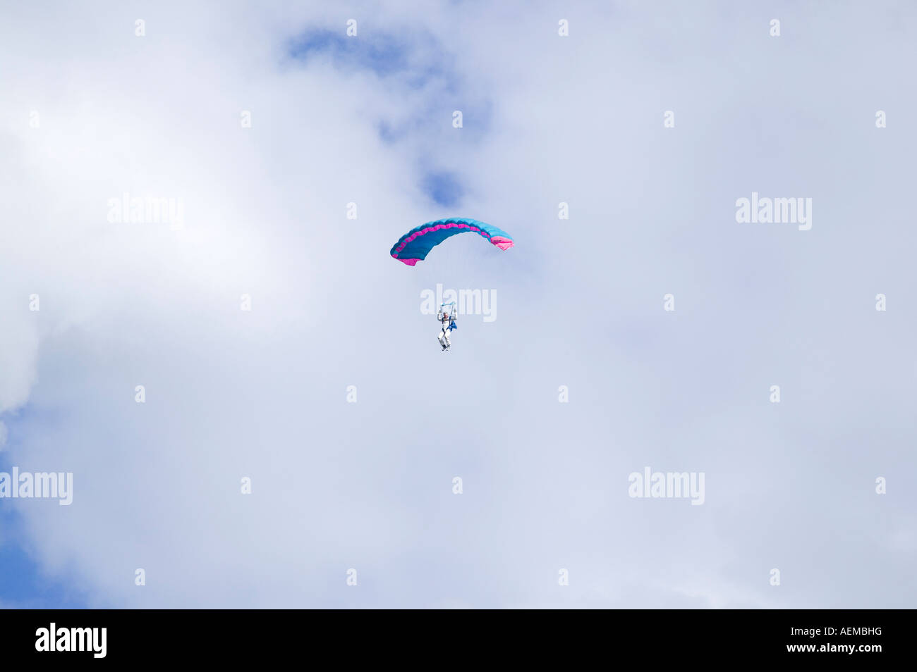 acrobatic parachutist white jump suit blue parachute Stock Photo - Alamy