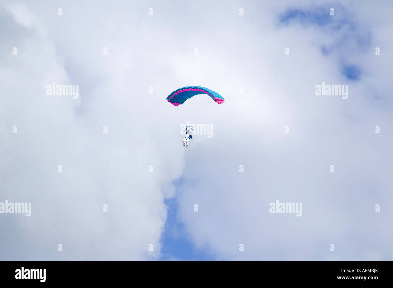acrobatic parachutist white jump suit blue parachute Stock Photo - Alamy
