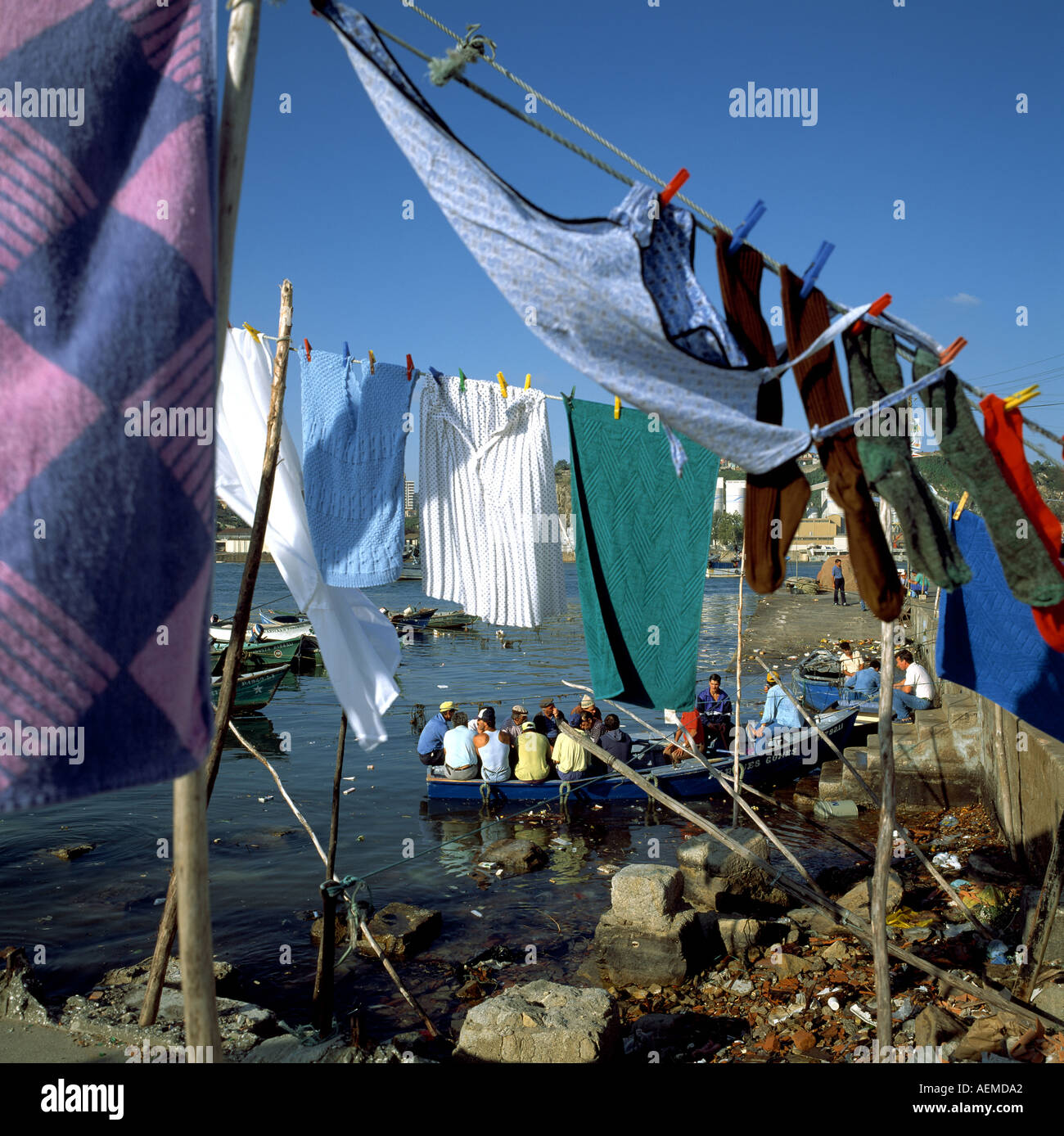 Laundry drying on washing line and fishermen meeting on boat, river ...