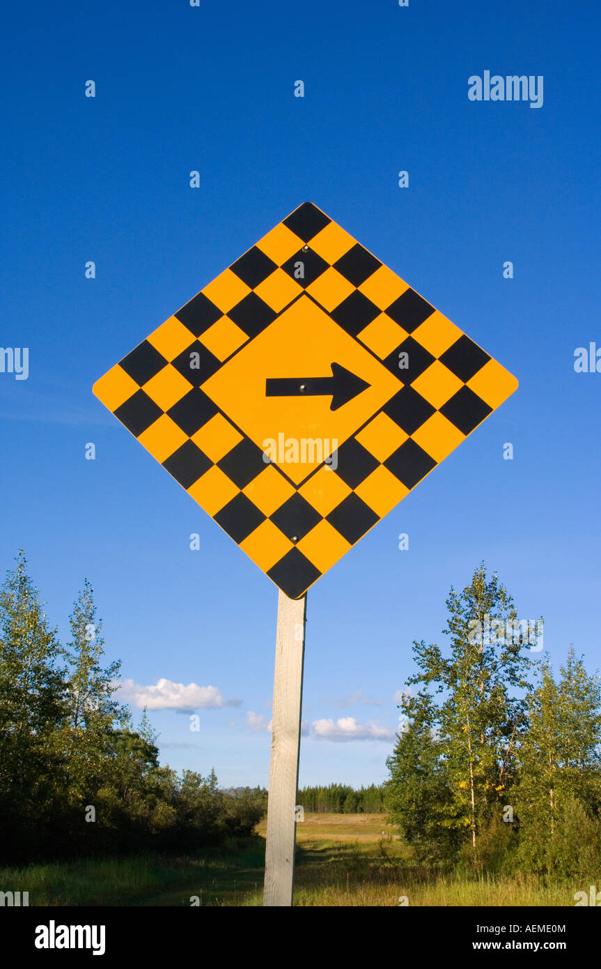 A yellow and black highway information sign on a blue sky background ...