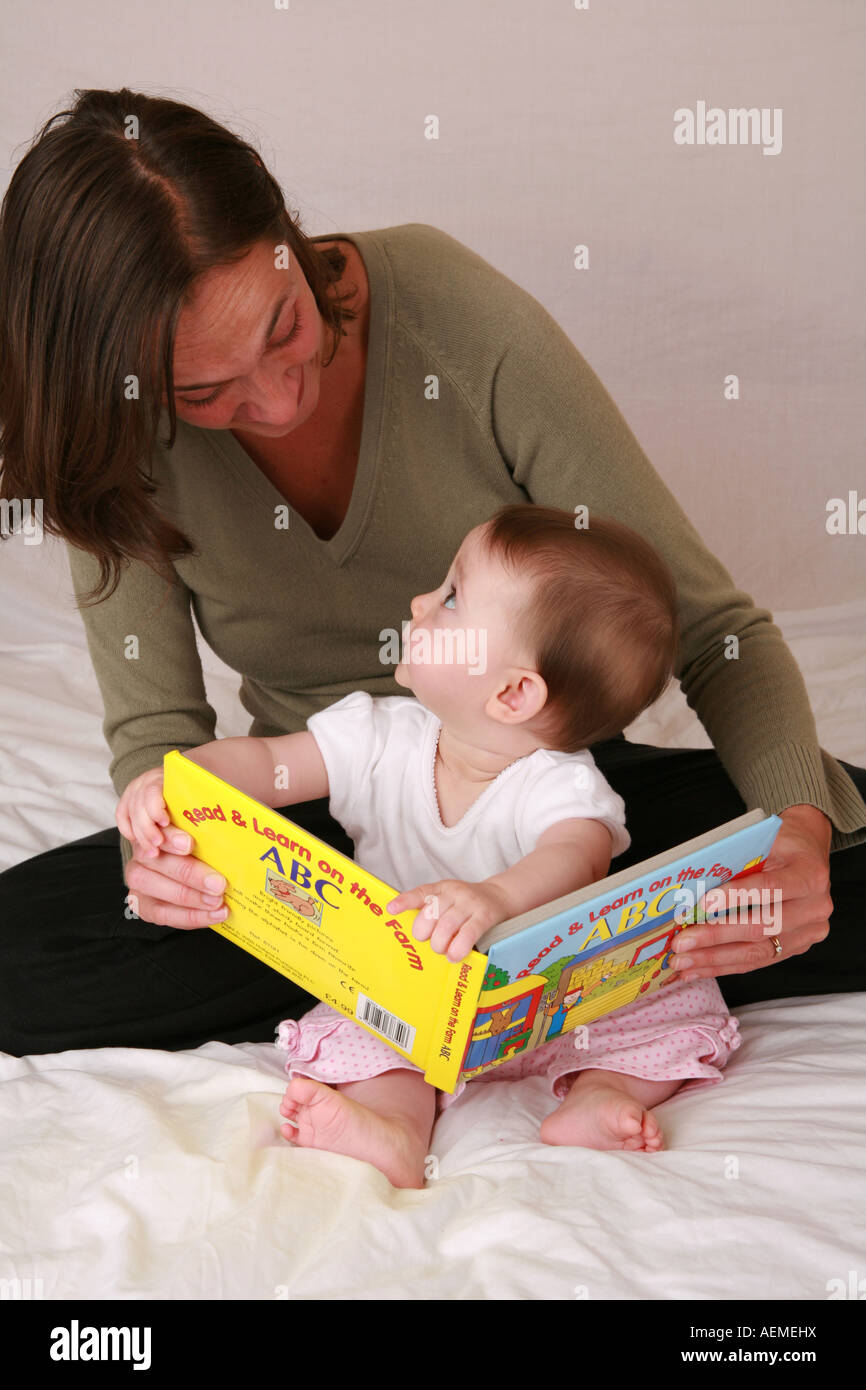 Cute young infant baby child reading a first ABC book at story time ...