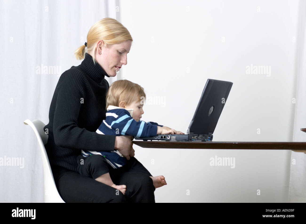 Working mother and toddler type on woman computer Stock Photo - Alamy