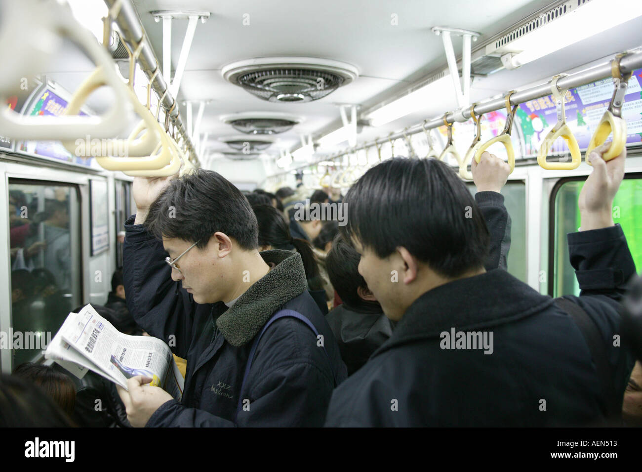 Han Chinese male reading newspaper on Beijing subway train Stock Photo ...