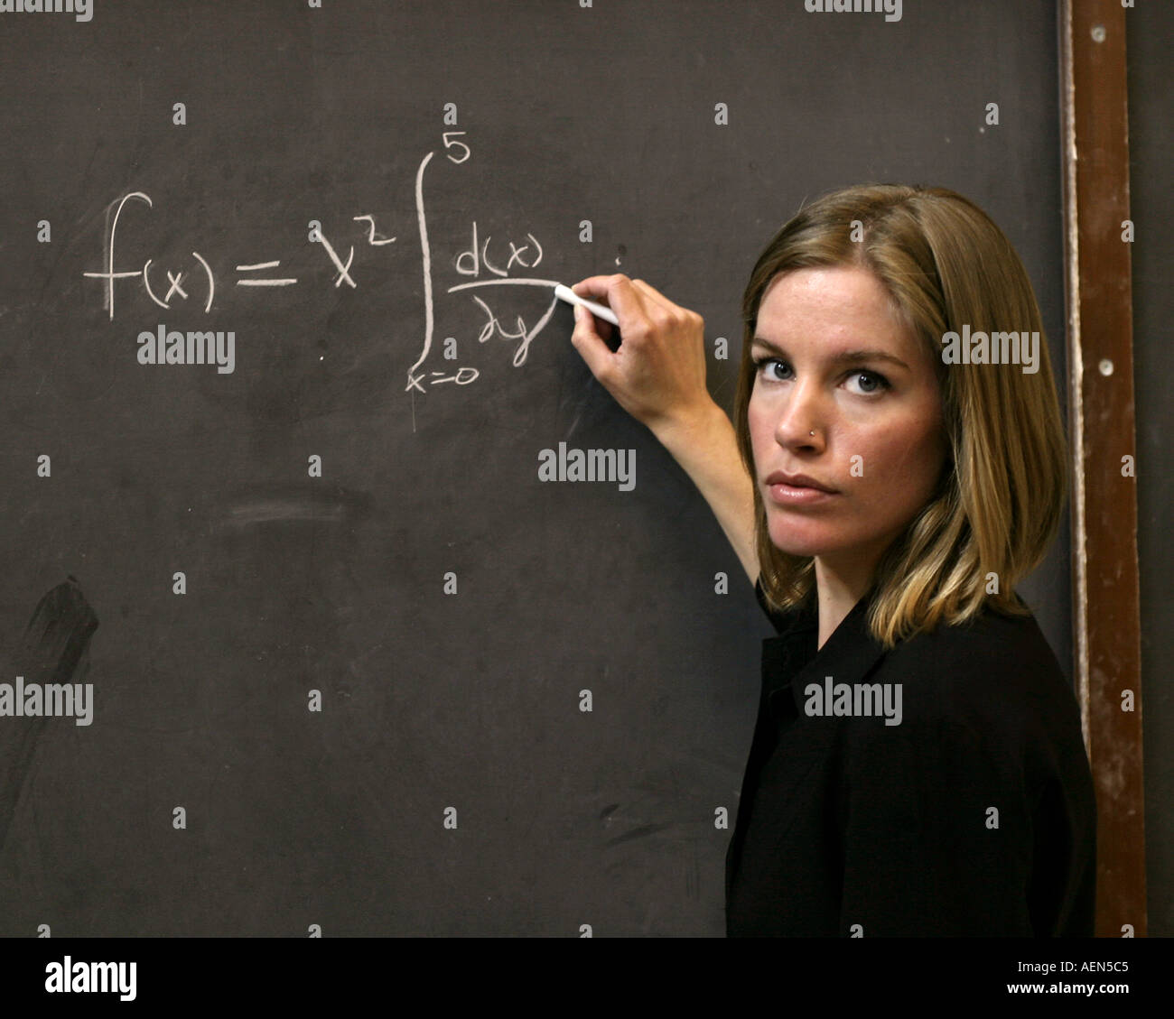 Math Teacher writing on a black board Stock Photo - Alamy
