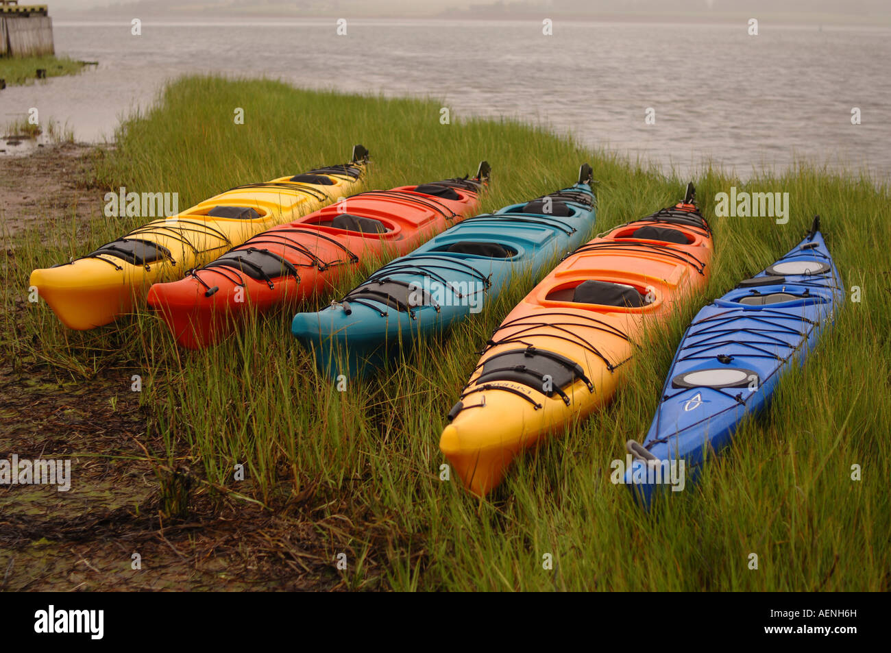 Kayaks sitting on the side of a lake Stock Photo - Alamy