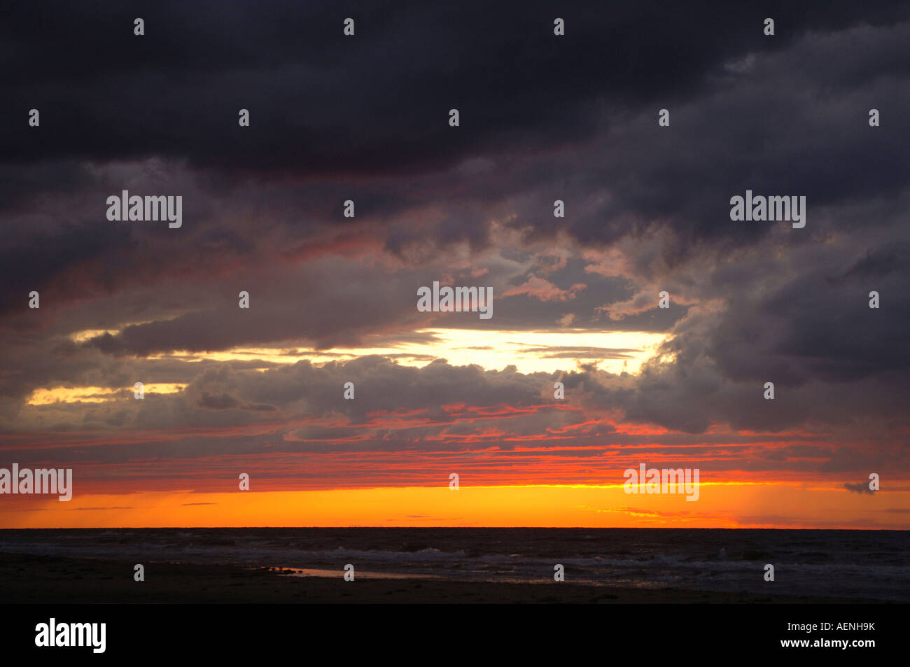 A stunning beach sunset behind clouds Stock Photo - Alamy
