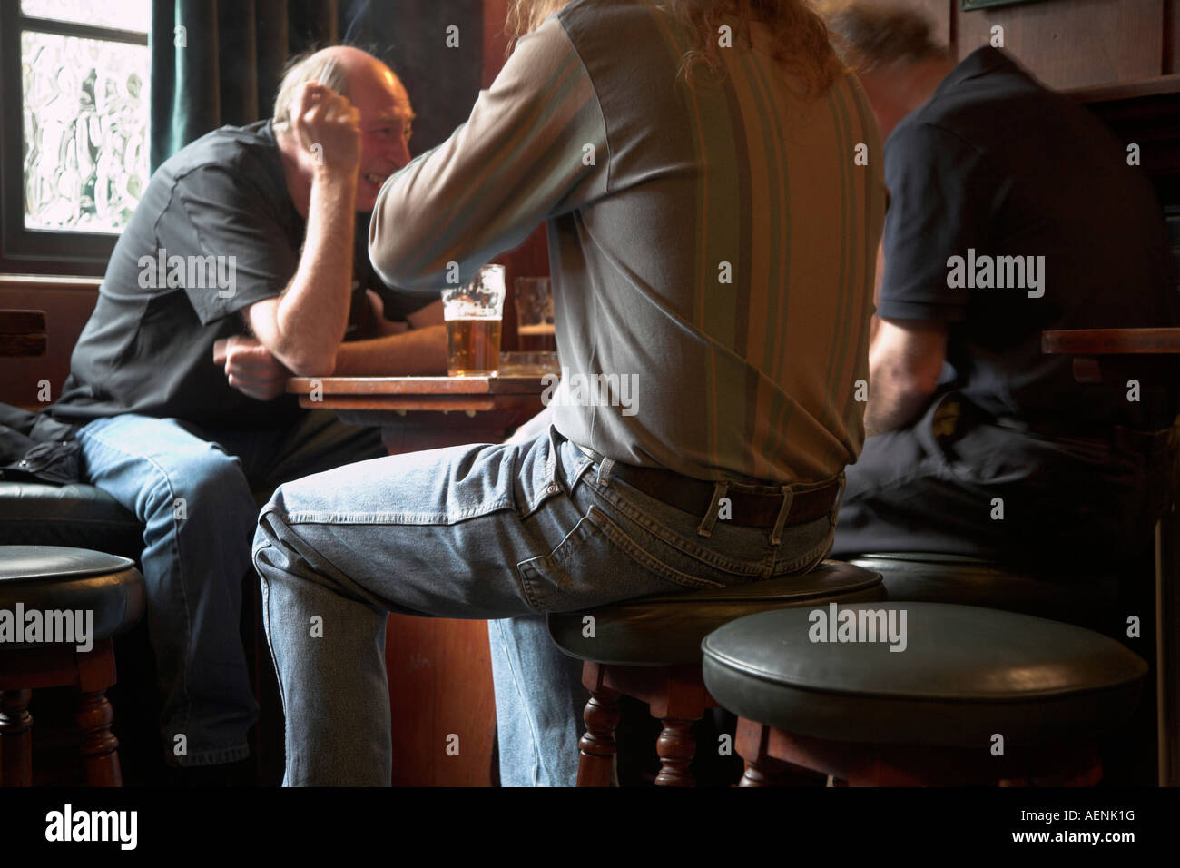Men sitting on stools in a bar Stock Photo - Alamy