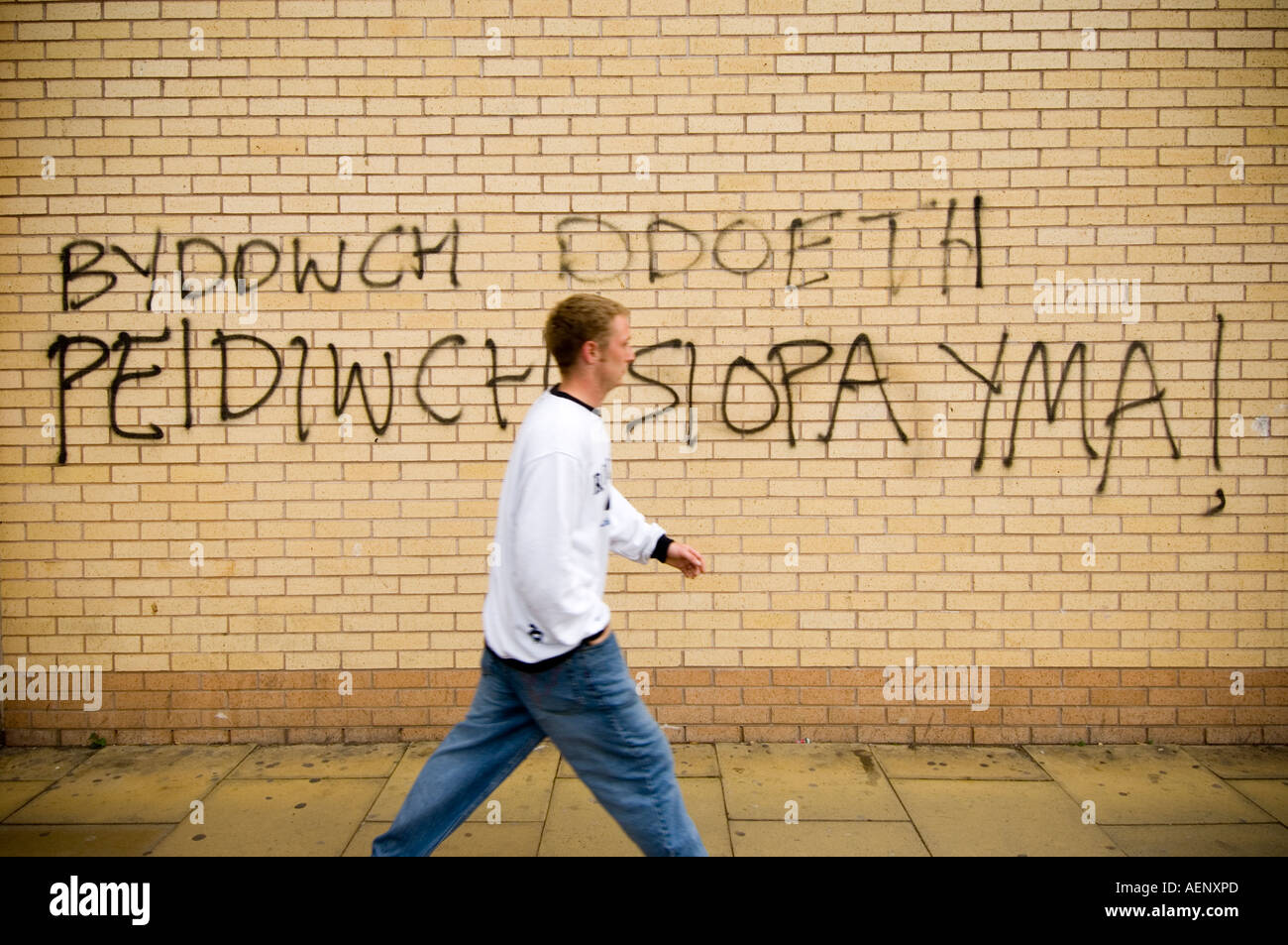 Welsh language political protest graffiti on B Wise shop wall "be wise ...
