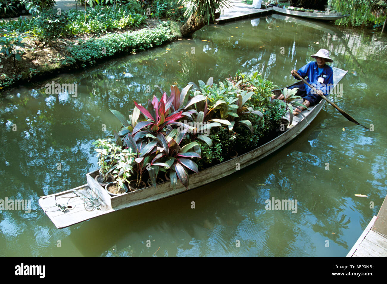 Lady rowing boat containing plants, Riverside Rose Garden, Sampran ...