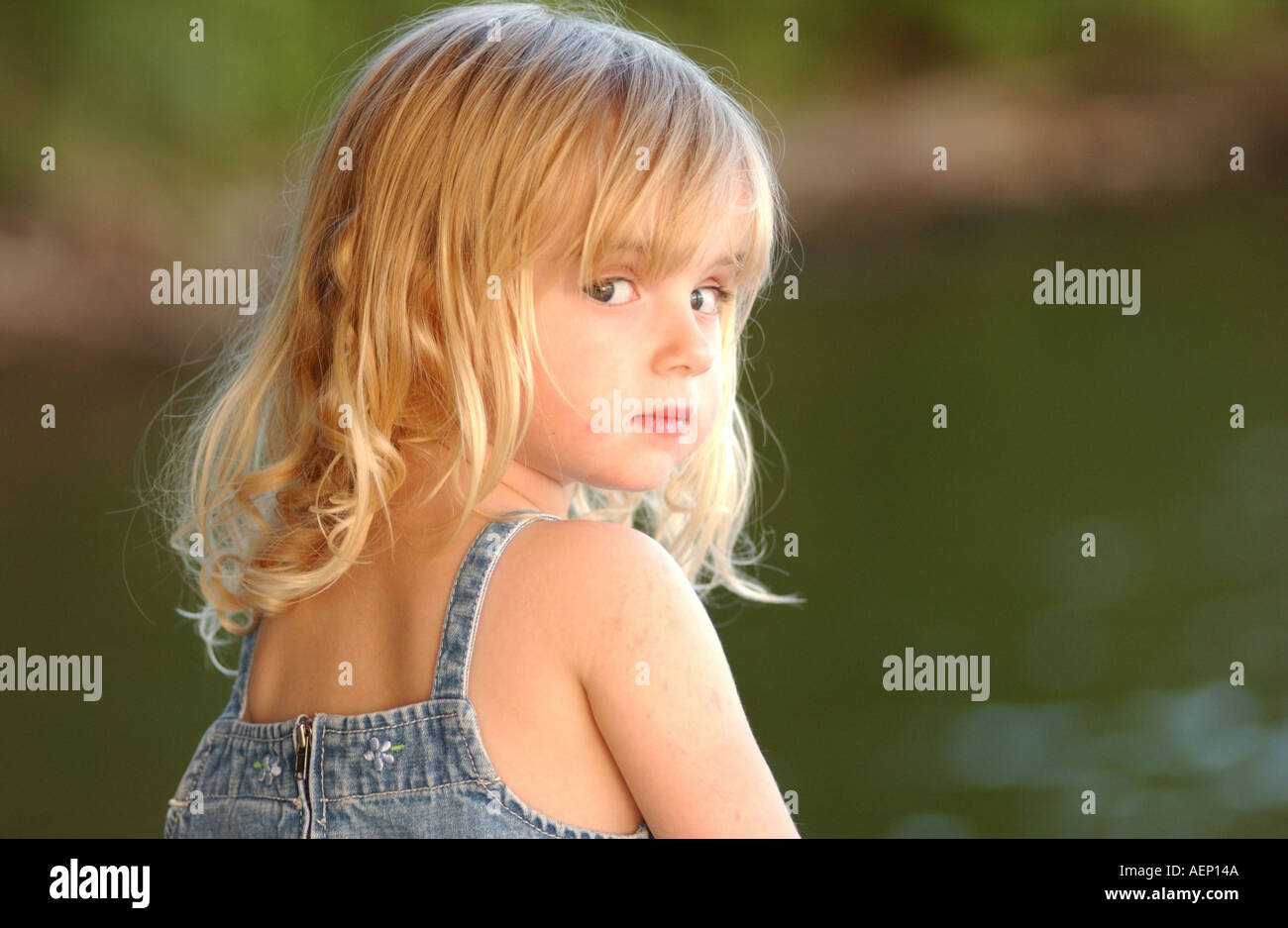 Young blond girl looking back over her shoulder Stock Photo - Alamy