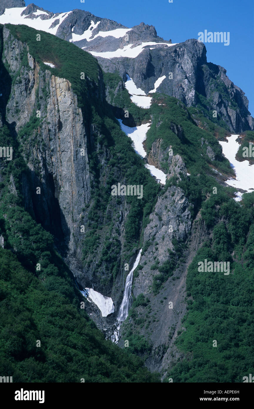 USA Alaska Kenai Fjords National Park Spring snow melt feeds waterfall in Kenai Mountains at end ...