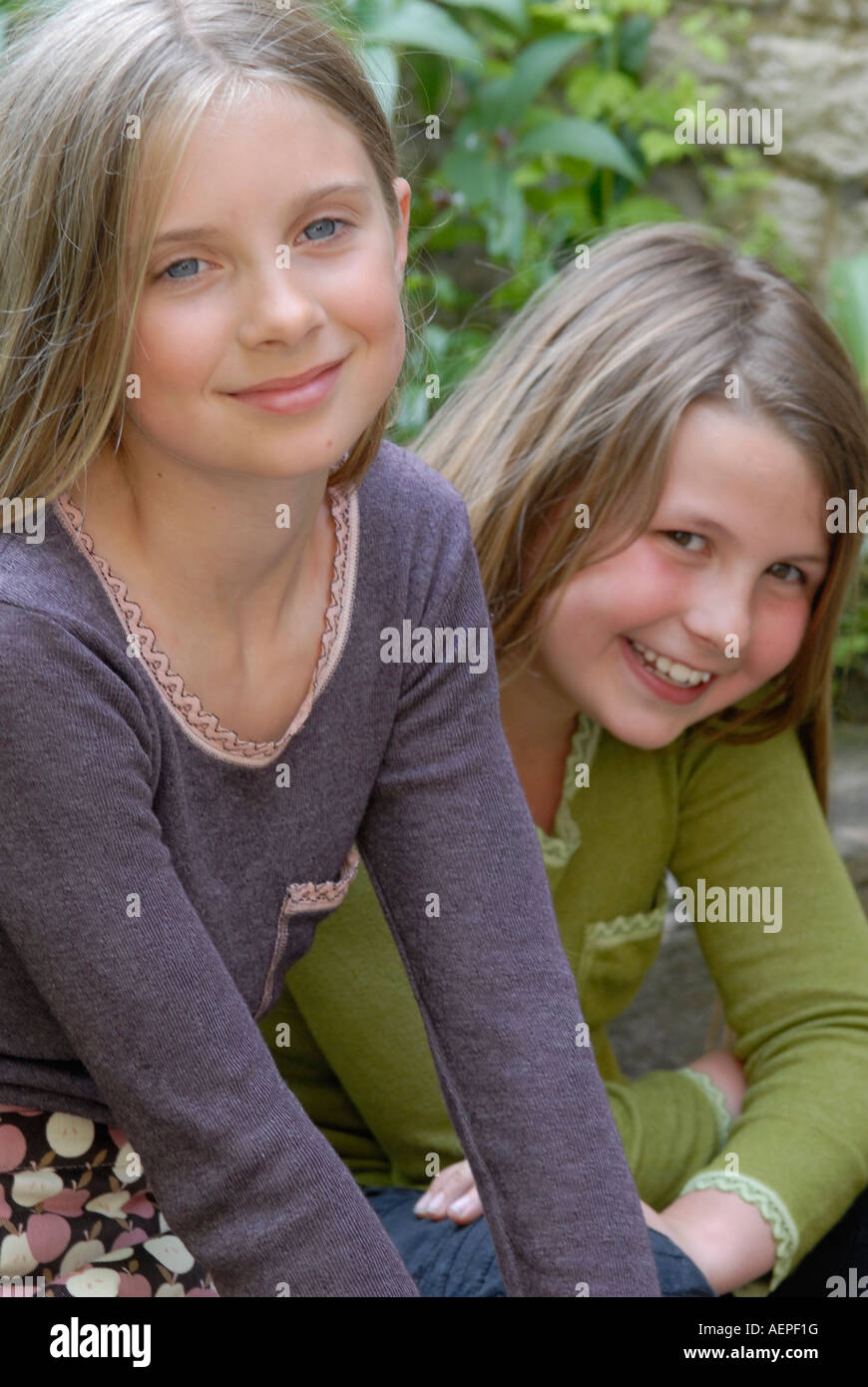 Portrait of two young girls, one girl looking serene, one girl looking ...