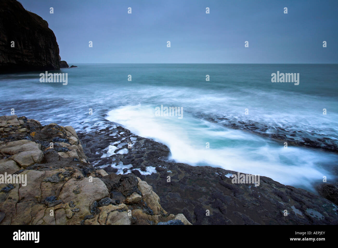 Waves surge into a large rock pool on Dancing Ledge, Purbeck, Dorset ...
