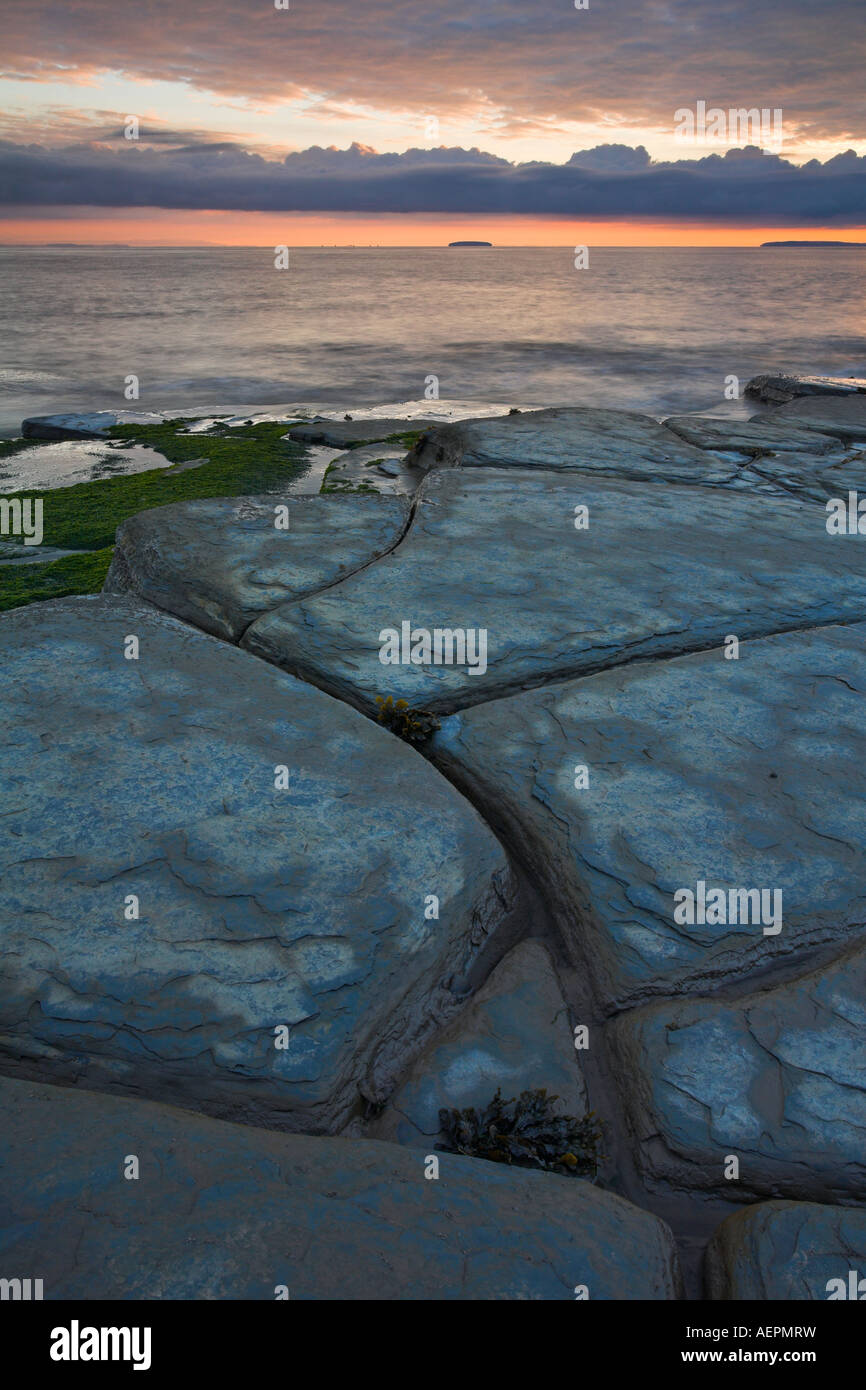 Sunrise over the Bristol Channel. Limestone ledges of Kilve beach are ...