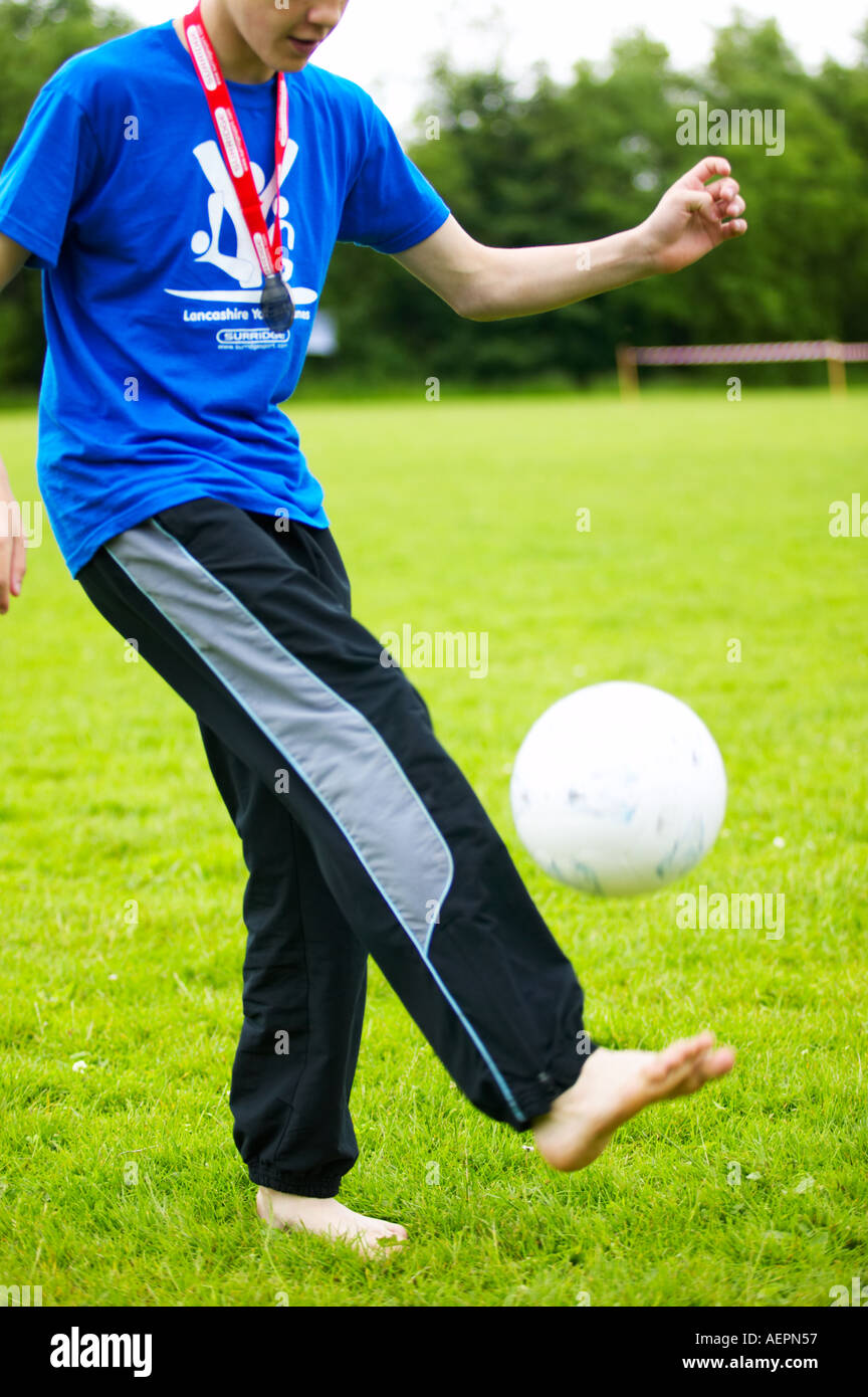 young boy balancing football on his bare foot Stock Photo - Alamy