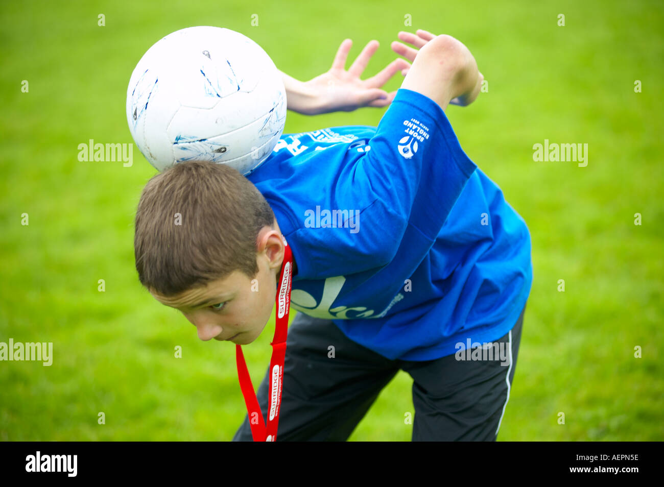 young boy bouncing football on his head Stock Photo - Alamy