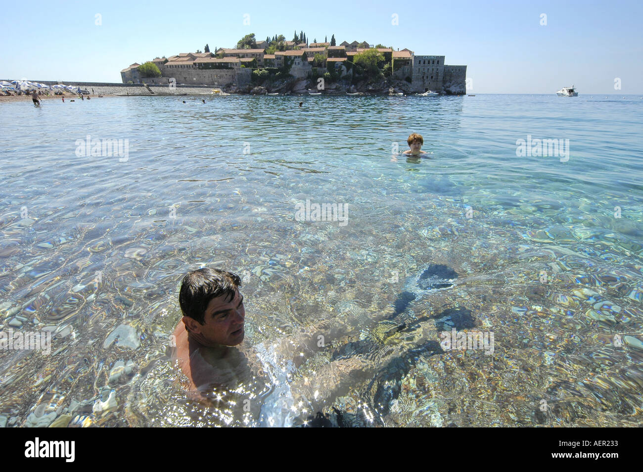 two people swimming near hotel Sveti Stefan Stock Photo - Alamy