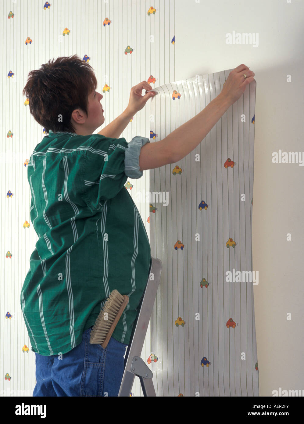 Pregnant woman papering the baby room Stock Photo - Alamy