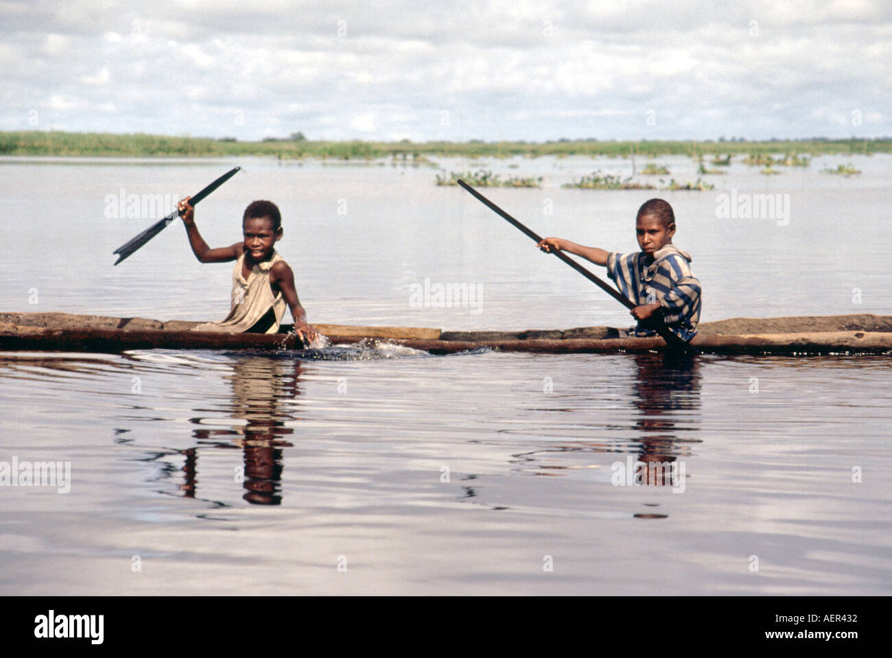 Two boys in a canoe on the flooded Sepik River during wet season Papua ...