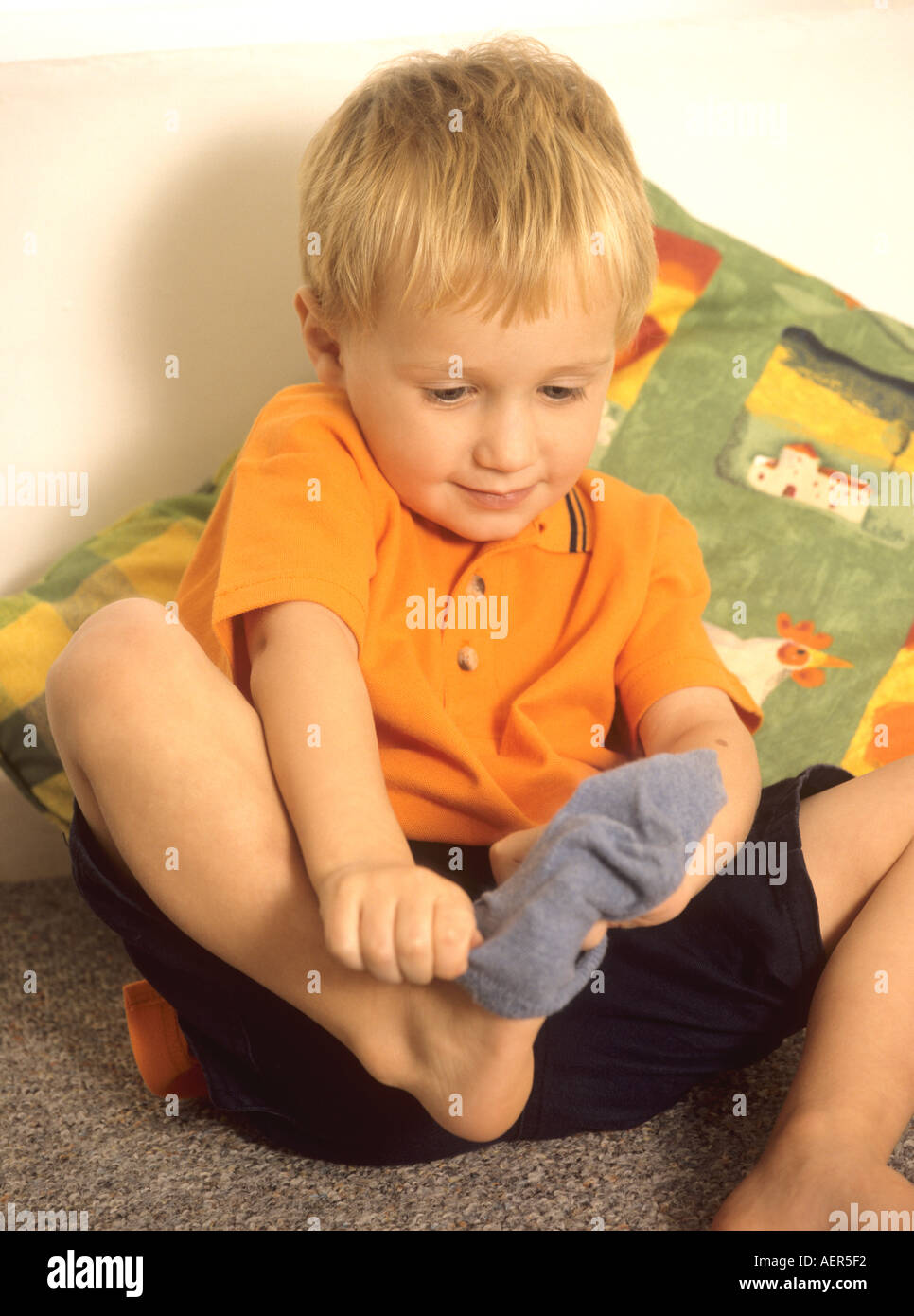 Young boy learning to dress himself Stock Photo - Alamy