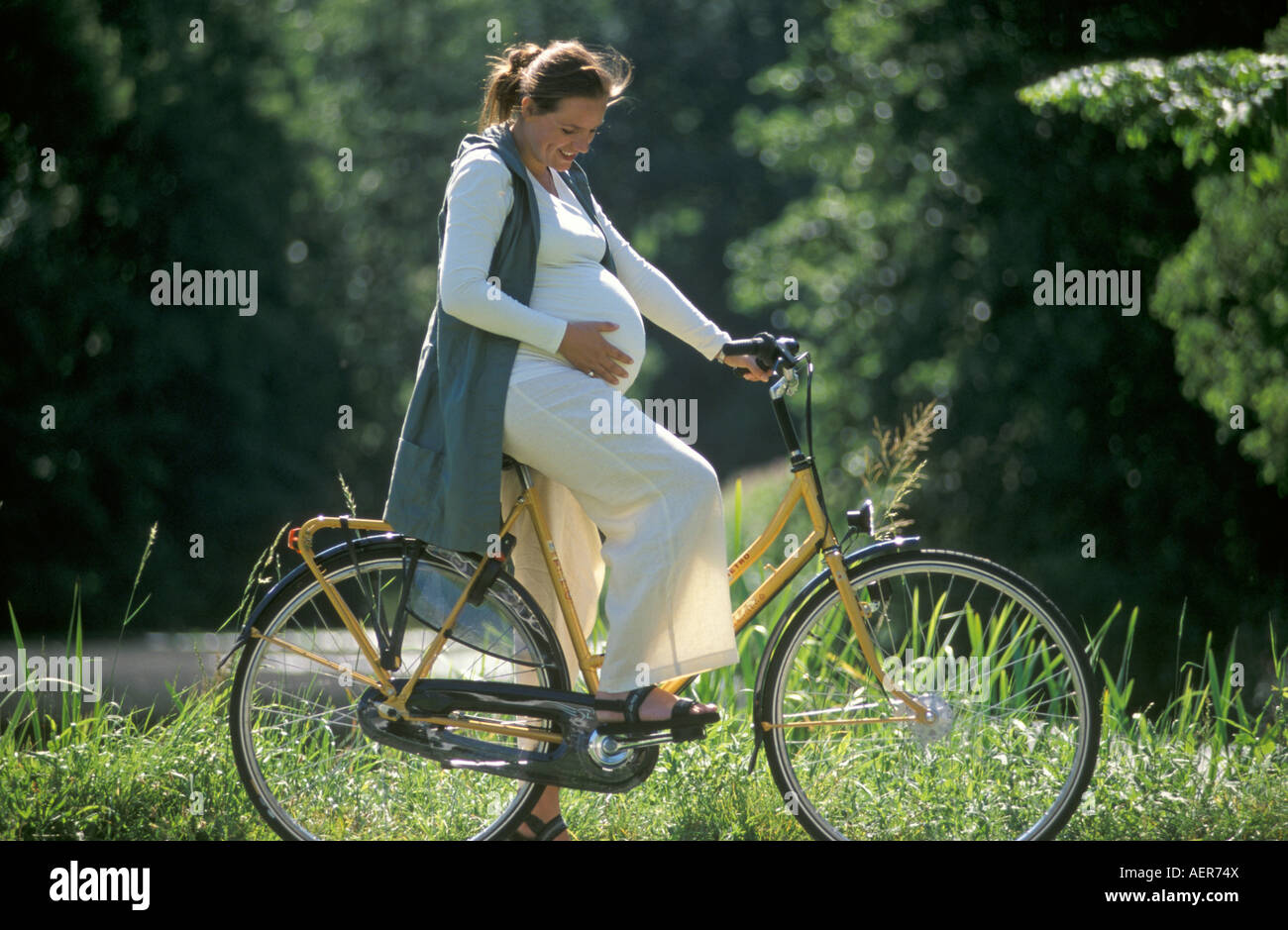 Pregnant woman on a bike Stock Photo - Alamy
