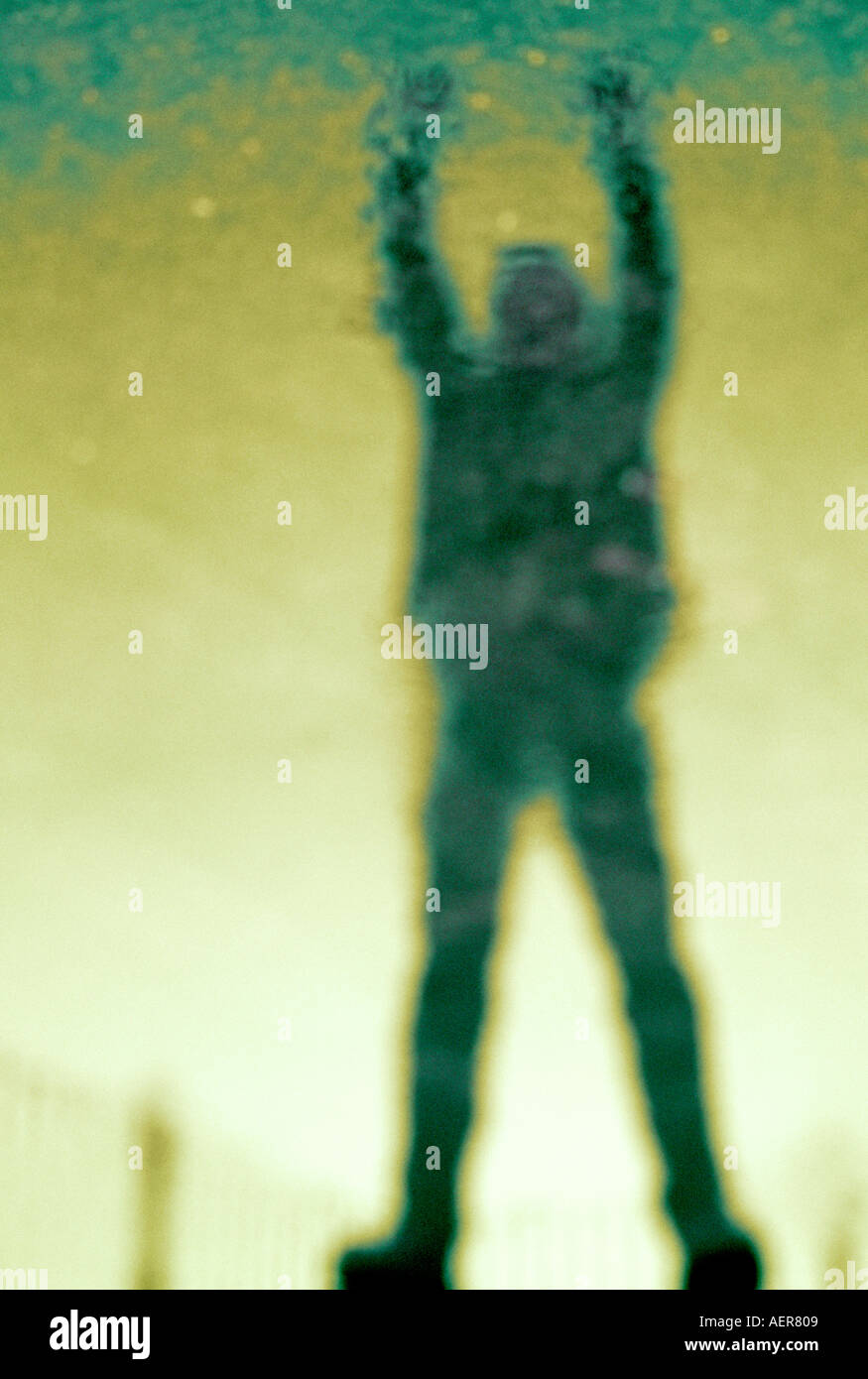 Man with arms raised reflection in wet ground distorted Stock Photo - Alamy
