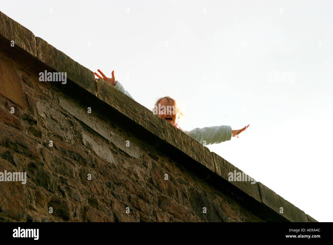 Young girl looking over castle wall Stock Photo - Alamy