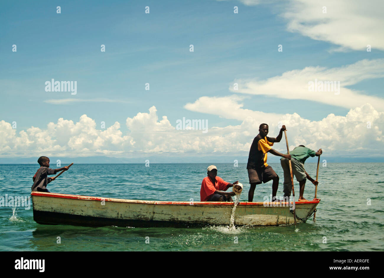 Men rowing a boat as the same time as emptying water out with a bucket ...