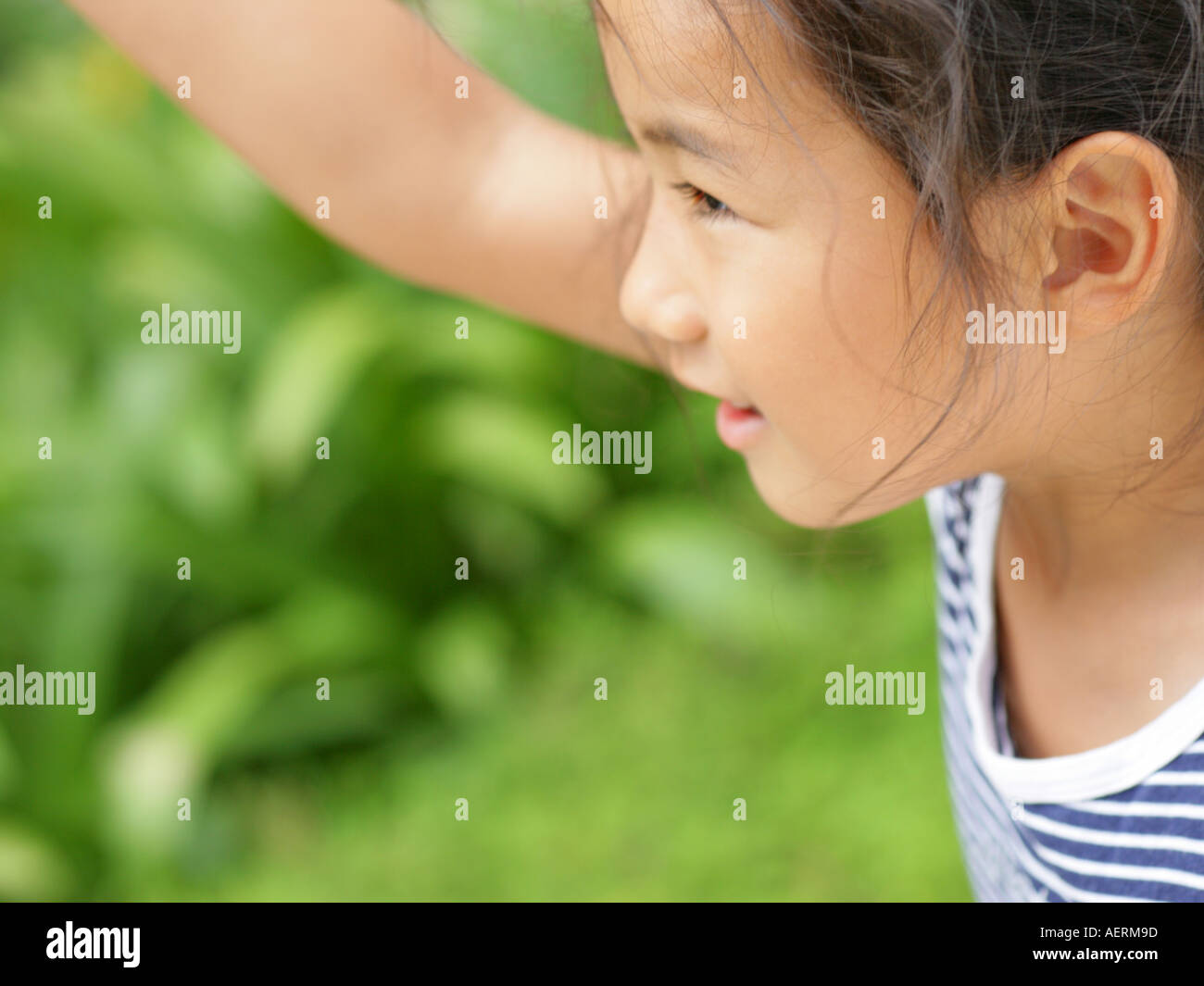 Side profile of a girl with her hand raised Stock Photo - Alamy