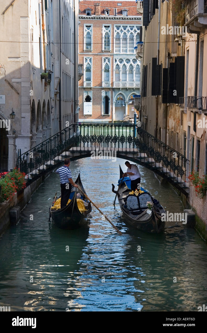 Two gondolas pass under bridge over canal Venice Italy Stock Photo - Alamy