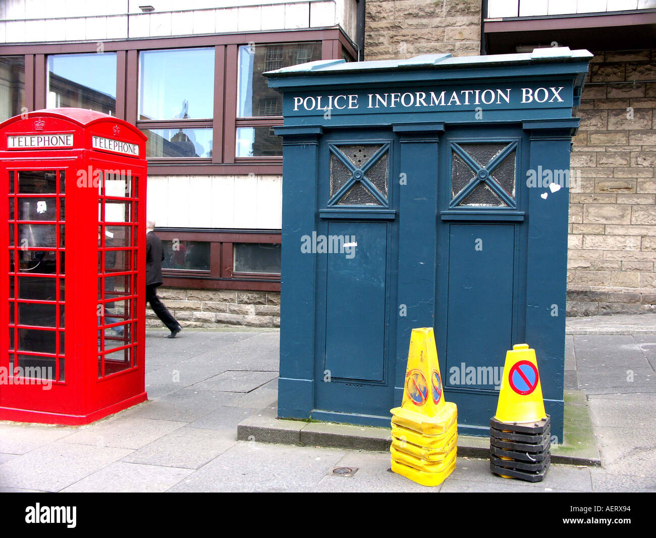 a red telephone box along side a police information box with stacks of ...