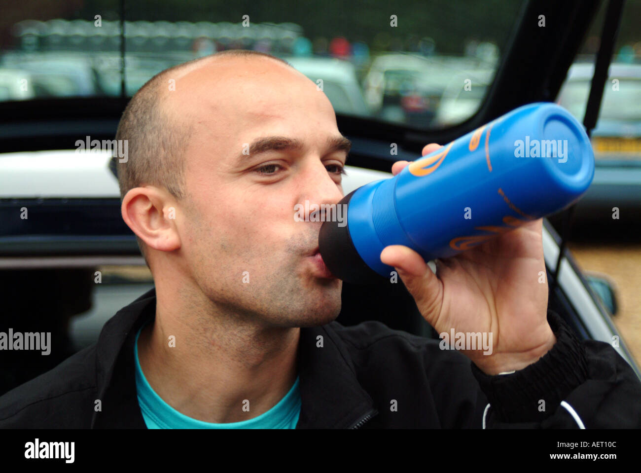 young man drinking from plastic bottle Stock Photo - Alamy