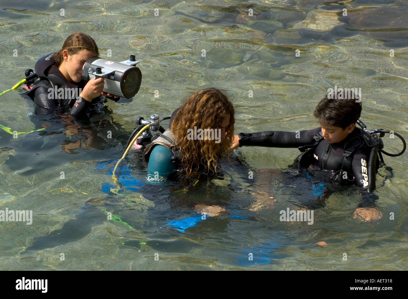 Israel Eilat Dolphin Reef diving teacher demonstraing to a young child ...