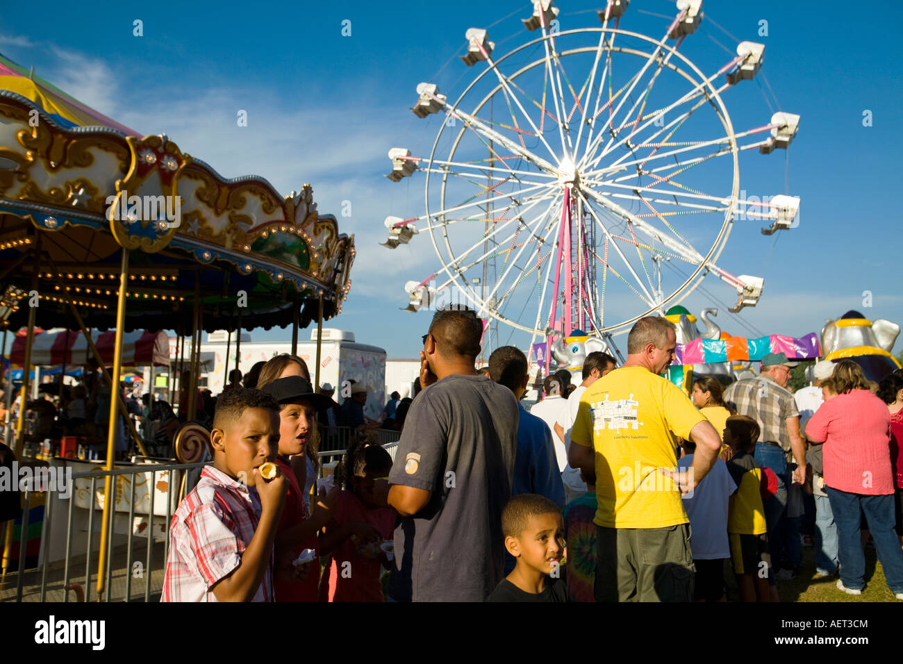 ILLINOIS Grayslake Boy eat ice cream cone crowd of people near ferris ...