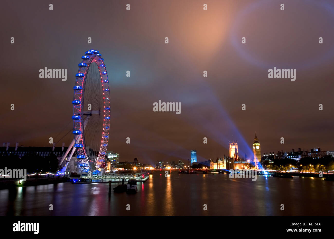 An illuminated night sky over the Thames near the London Eye big Ben ...