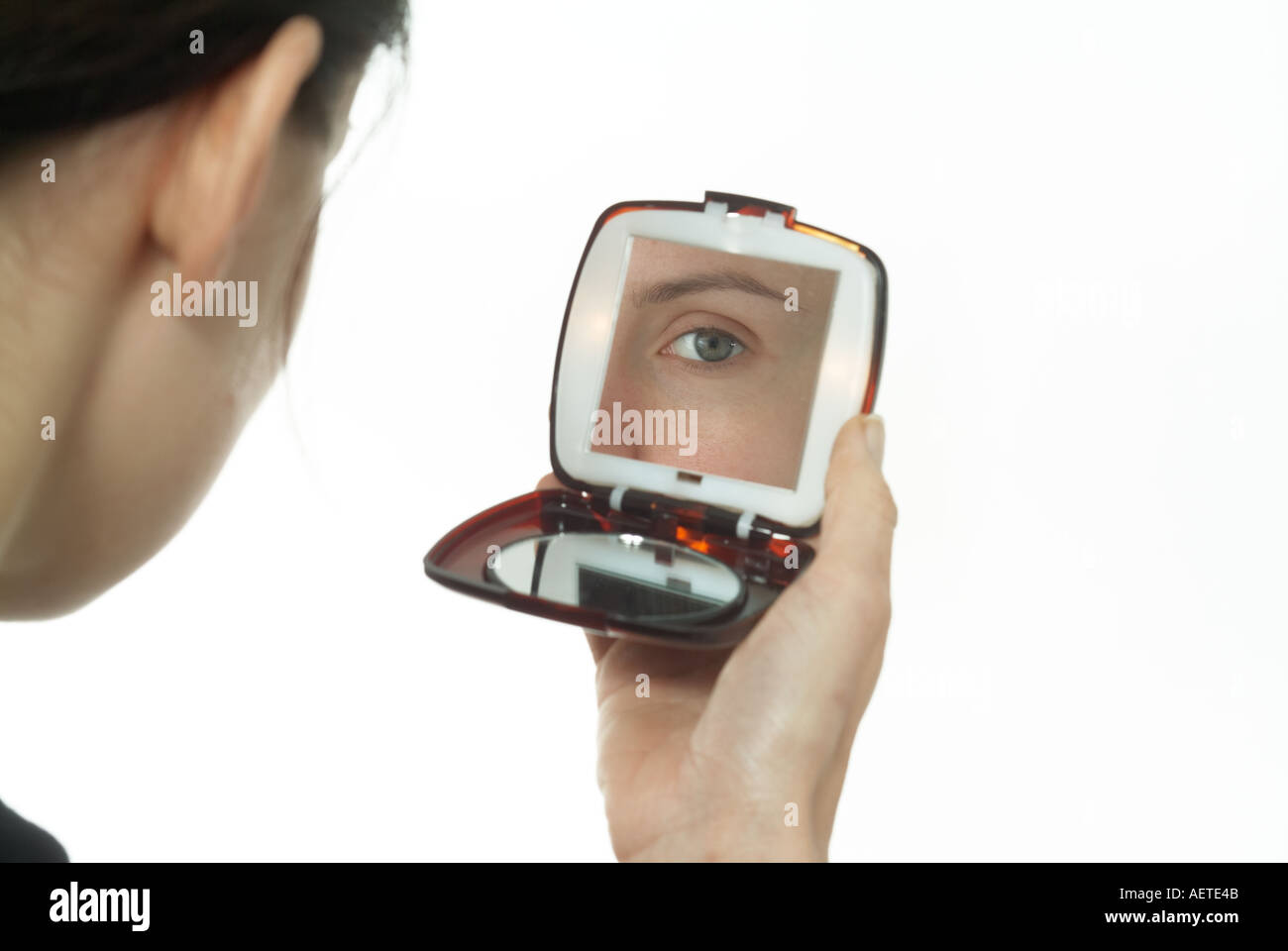 woman looking into a compact mirror Stock Photo - Alamy